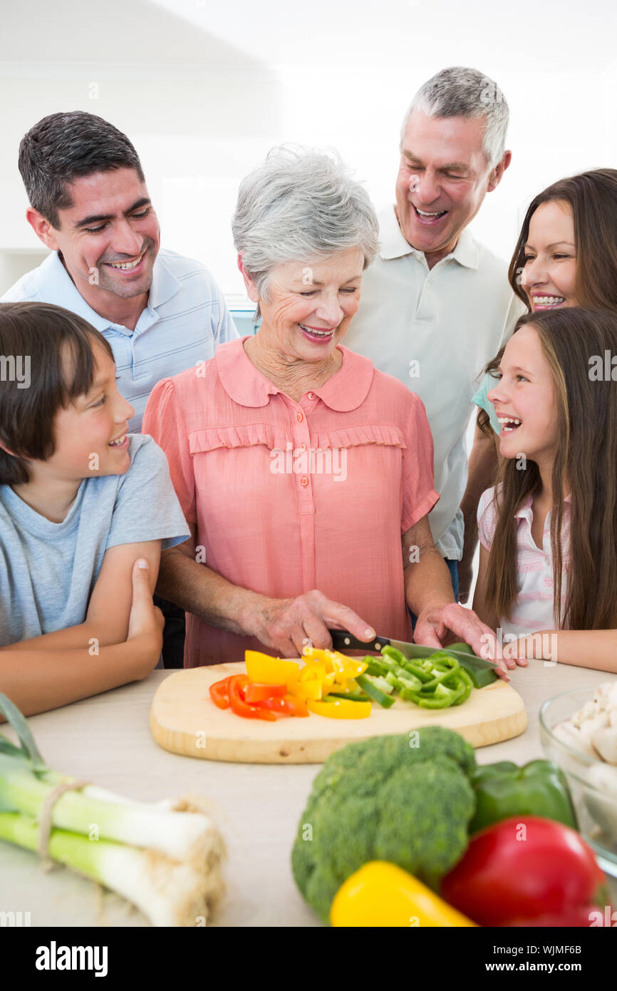 Smiling multigeneration family preparing food at counter Stock Photo ...