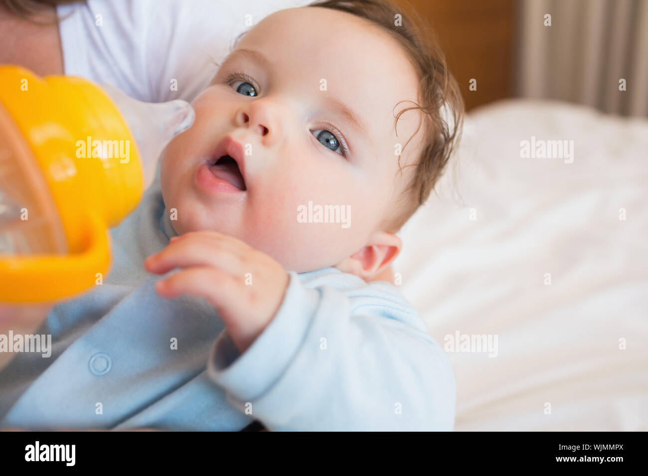 Cute baby boy being feed by mother at home Stock Photo - Alamy