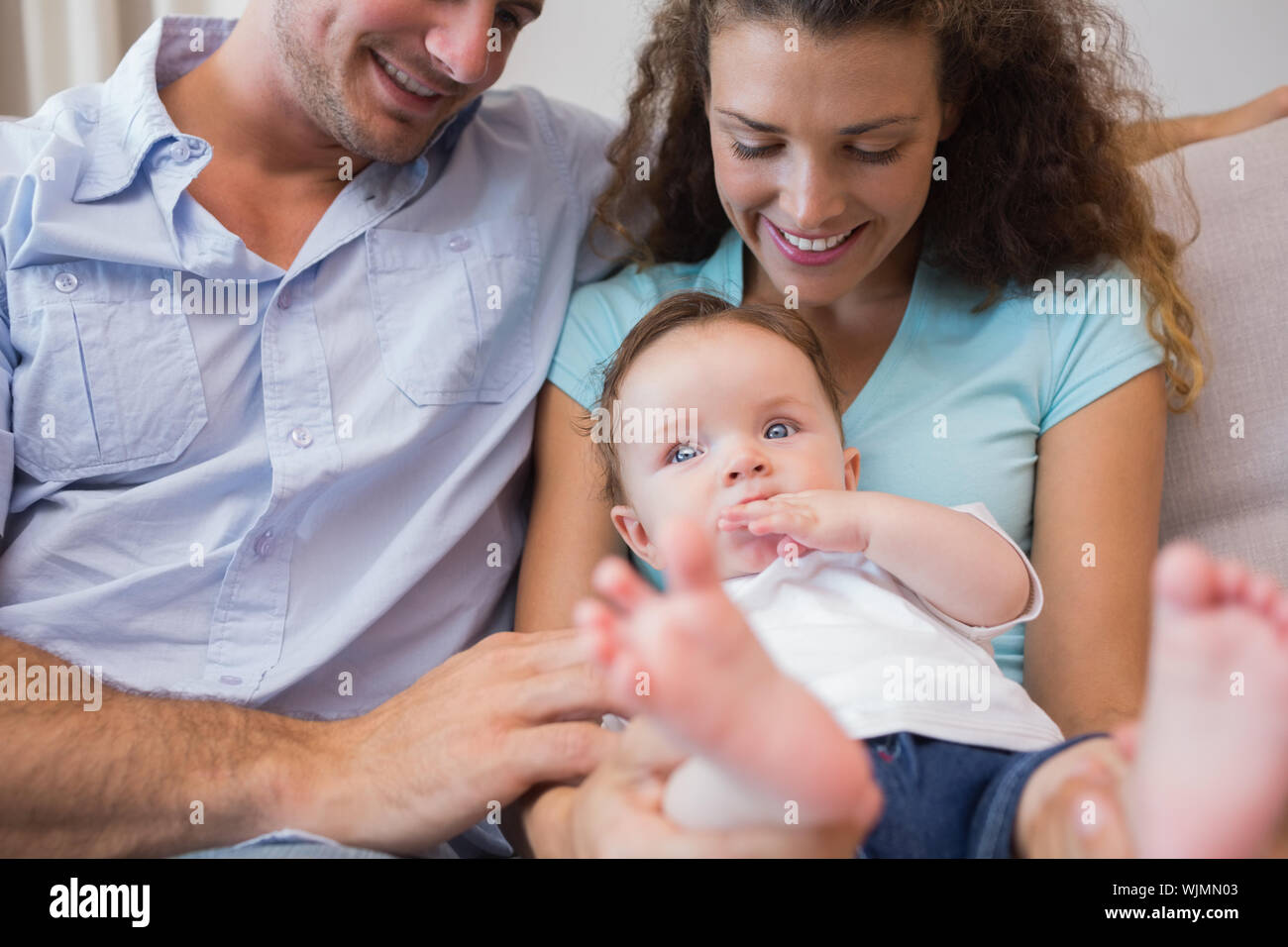 Happy parents looking at cute baby in living room Stock Photo - Alamy