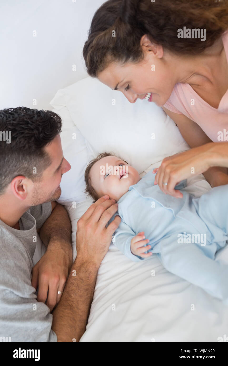 High angle view of caring parents with baby boy in bed Stock Photo - Alamy