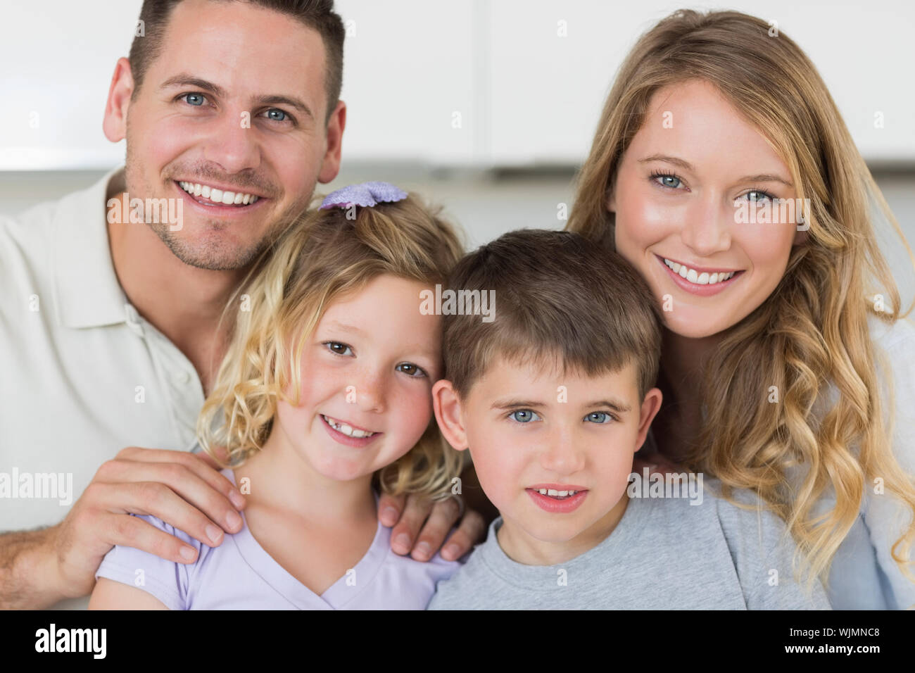 Closeup portrait of family smiling together in house Stock Photo - Alamy