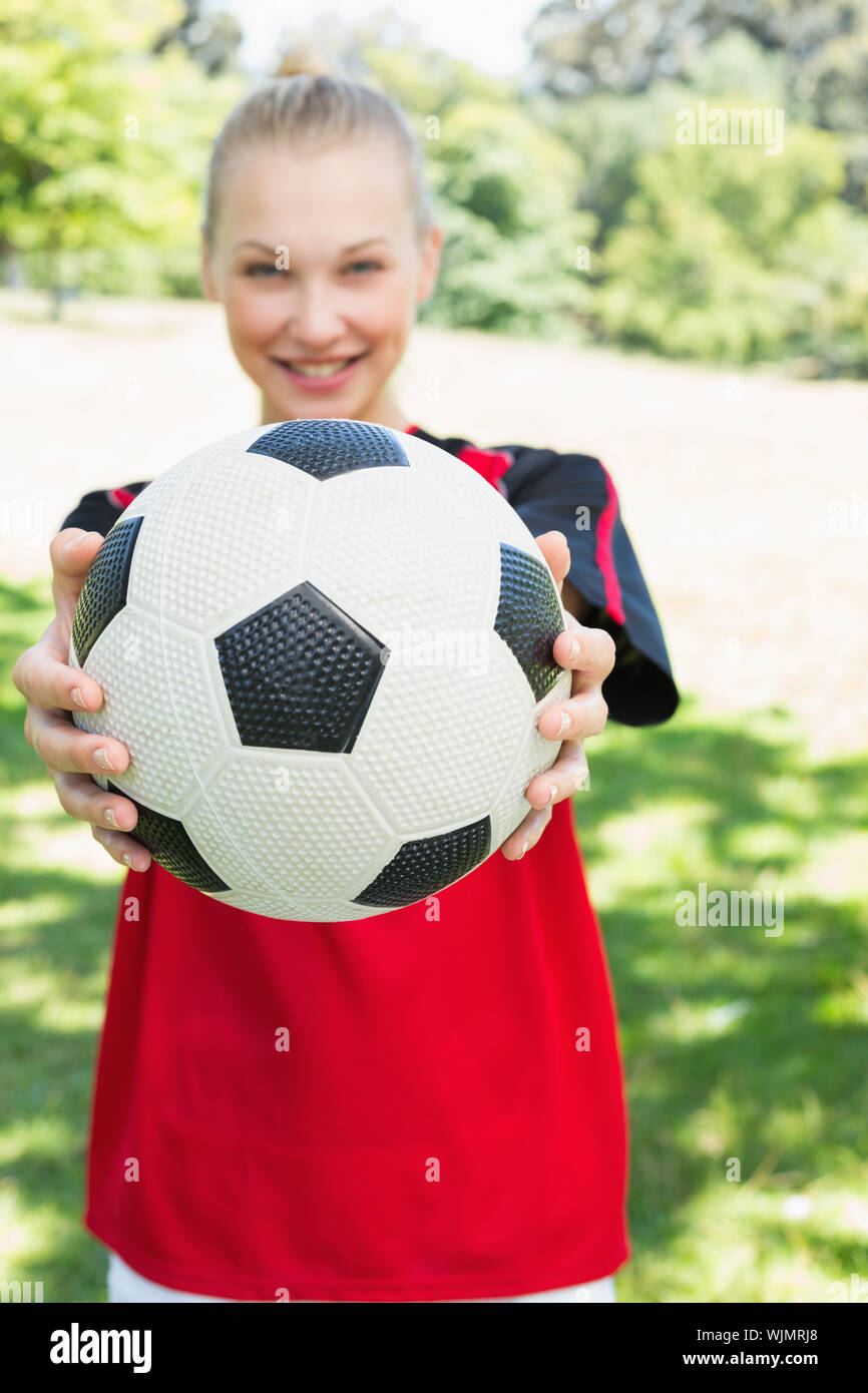 Portrait of female soccer player showing ball at park Stock Photo - Alamy