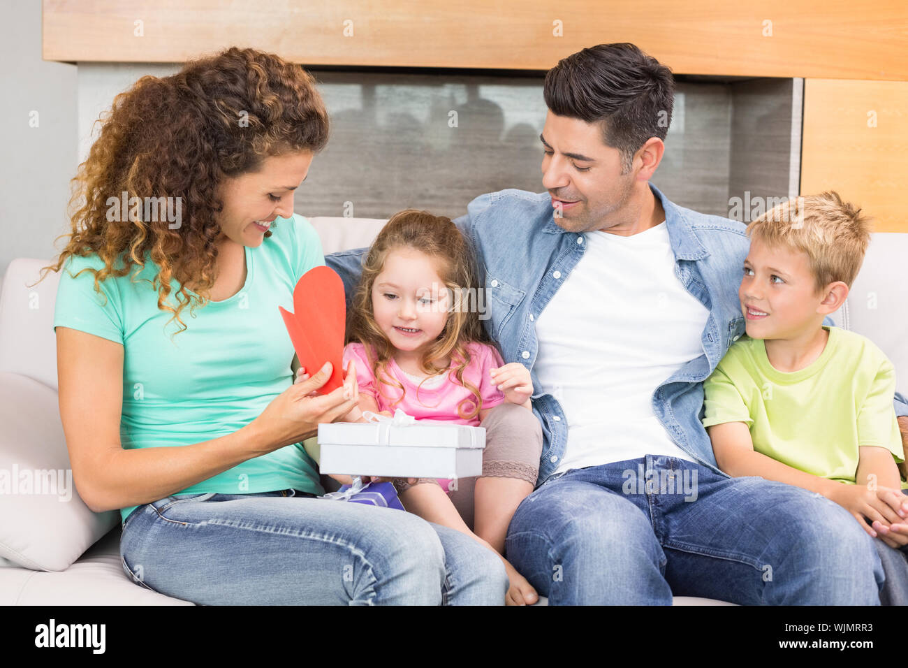 Happy family sitting on sofa celebrating a birthday at home in living ...