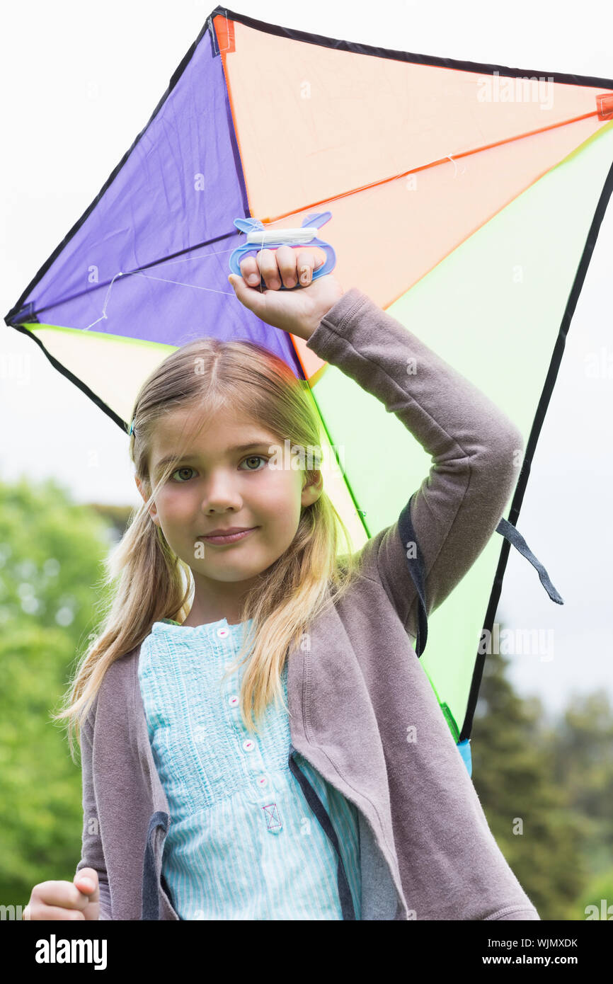 Portrait of a cute young girl with a kite standing outdoors Stock Photo ...