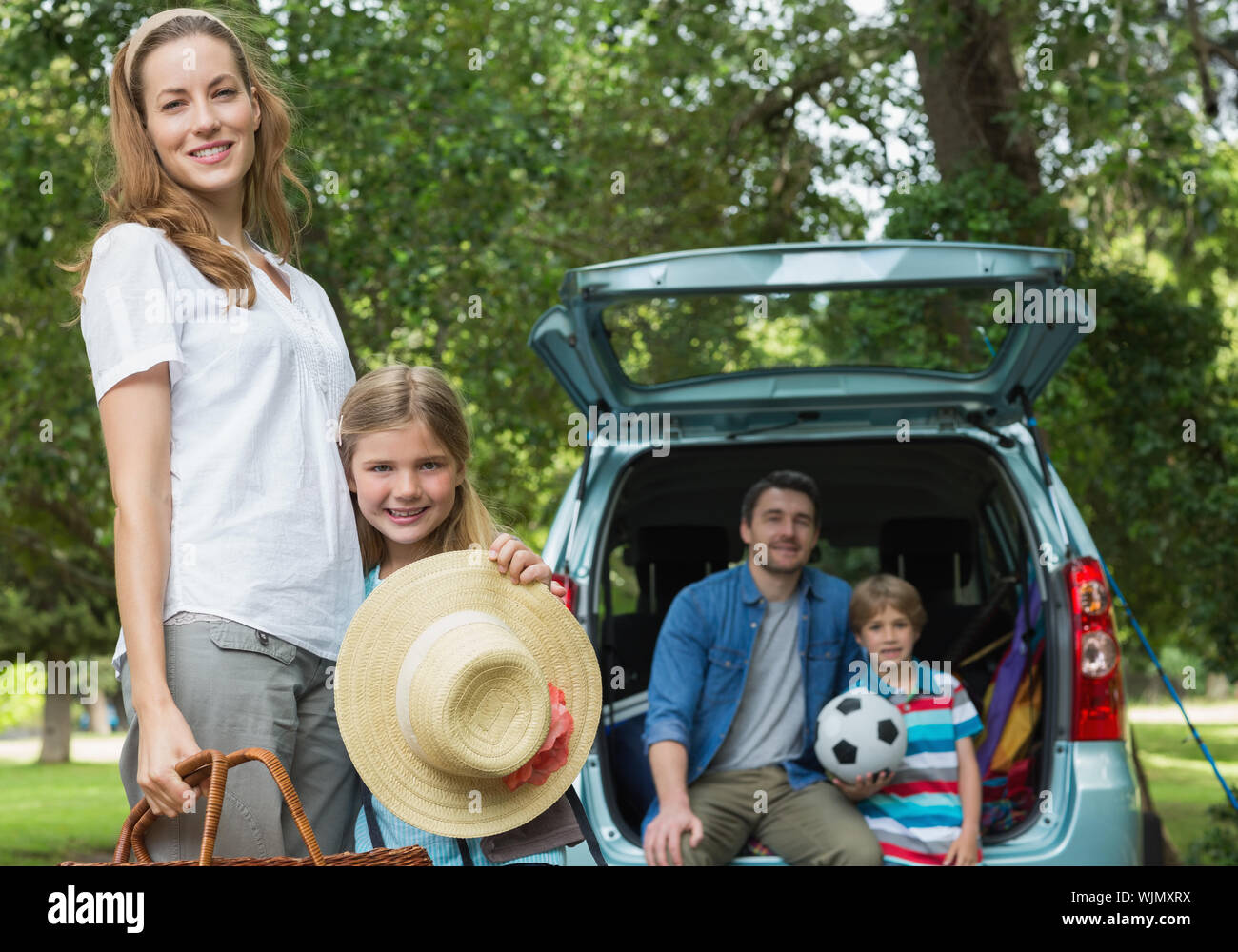Portrait of mother and daughter with father and son sitting in car ...