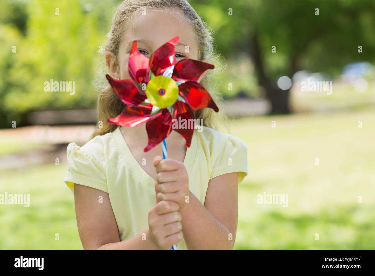 Close-up portrait of cute girl holding pinwheel at the park Stock Photo ...