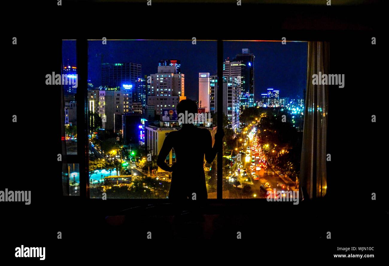 Silhouette Woman Looking Illuminated City Through Window At Night Stock ...