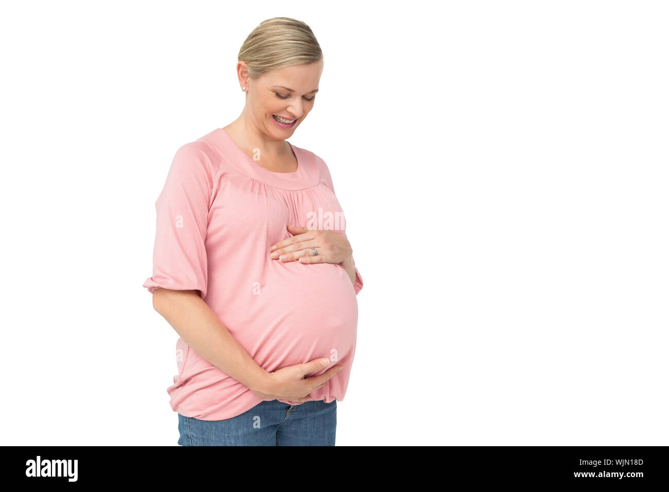 Pregnant woman looking down at her bump on white background Stock Photo ...