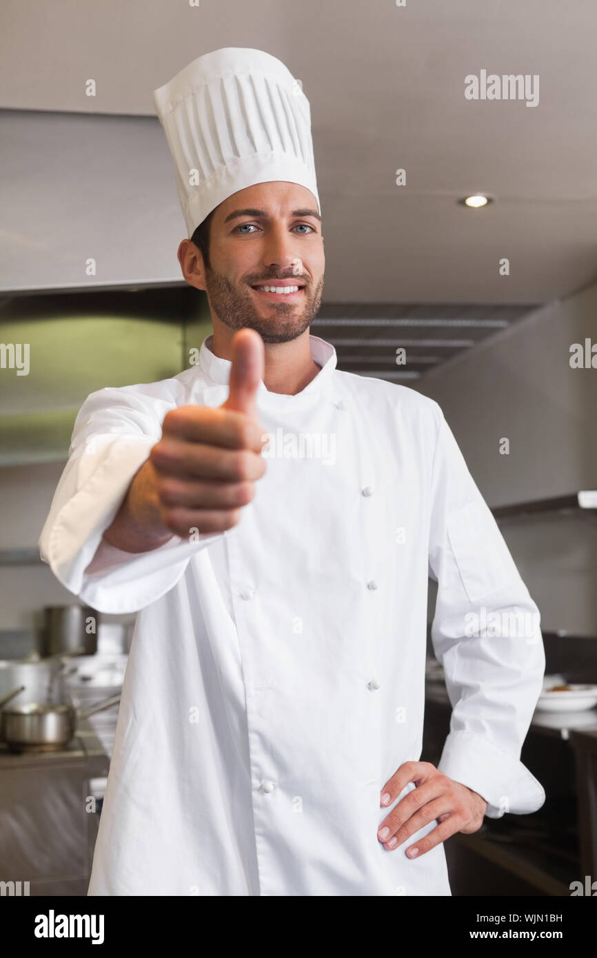 Happy young chef looking at camera showing thumb up in a commercial ...