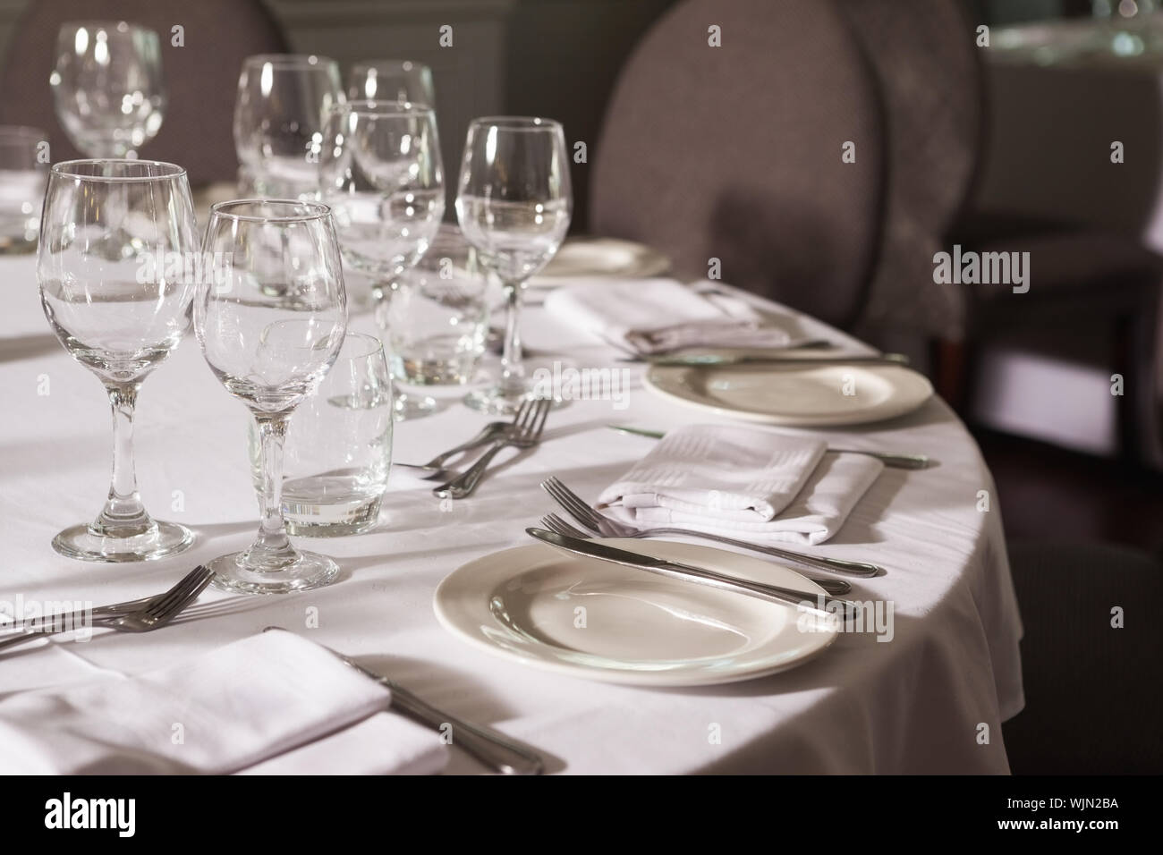 Set table with white linen in a fancy restaurant Stock Photo - Alamy