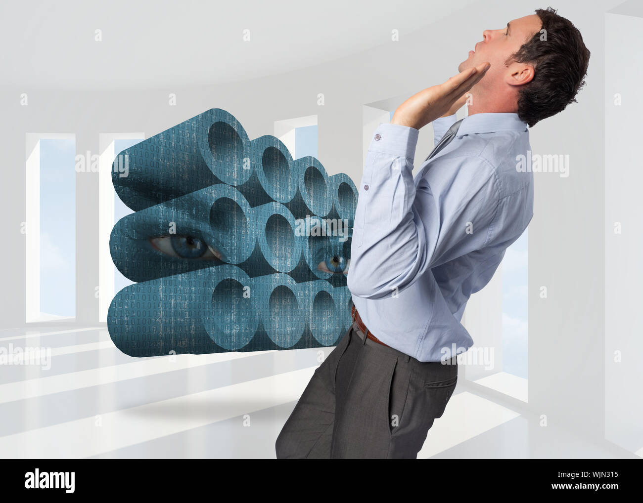 Businessman standing with arms pushing up against bright white room ...