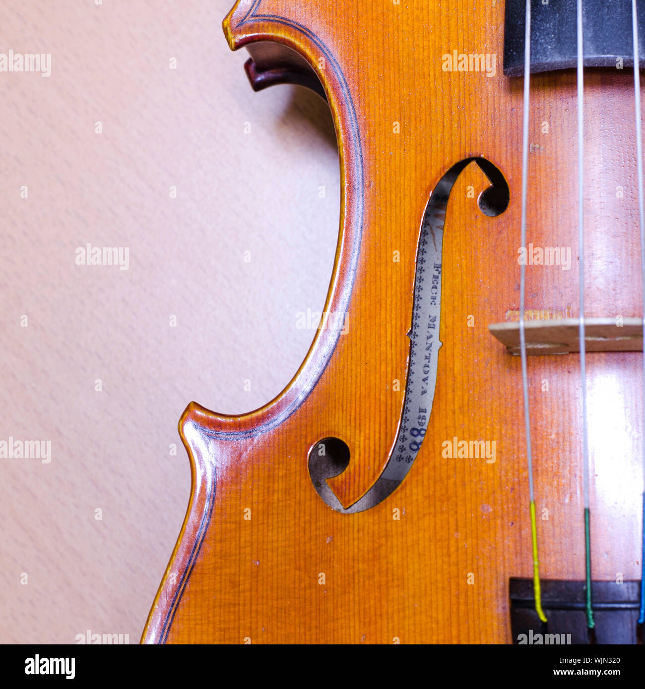 single soft brown violin with brown wallpaper Stock Photo - Alamy
