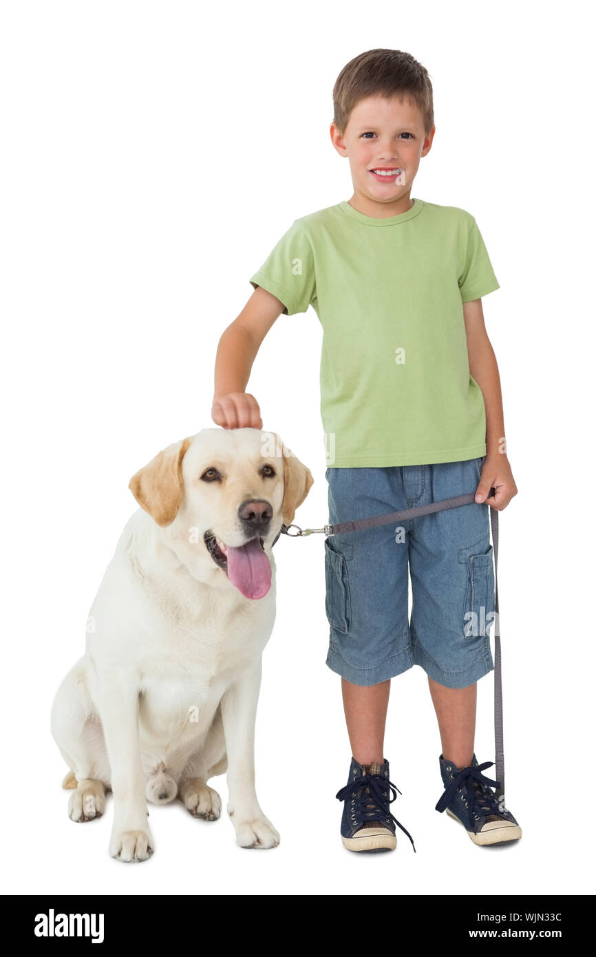 Cute little boy standing with his labrador dog smiling at camera on ...