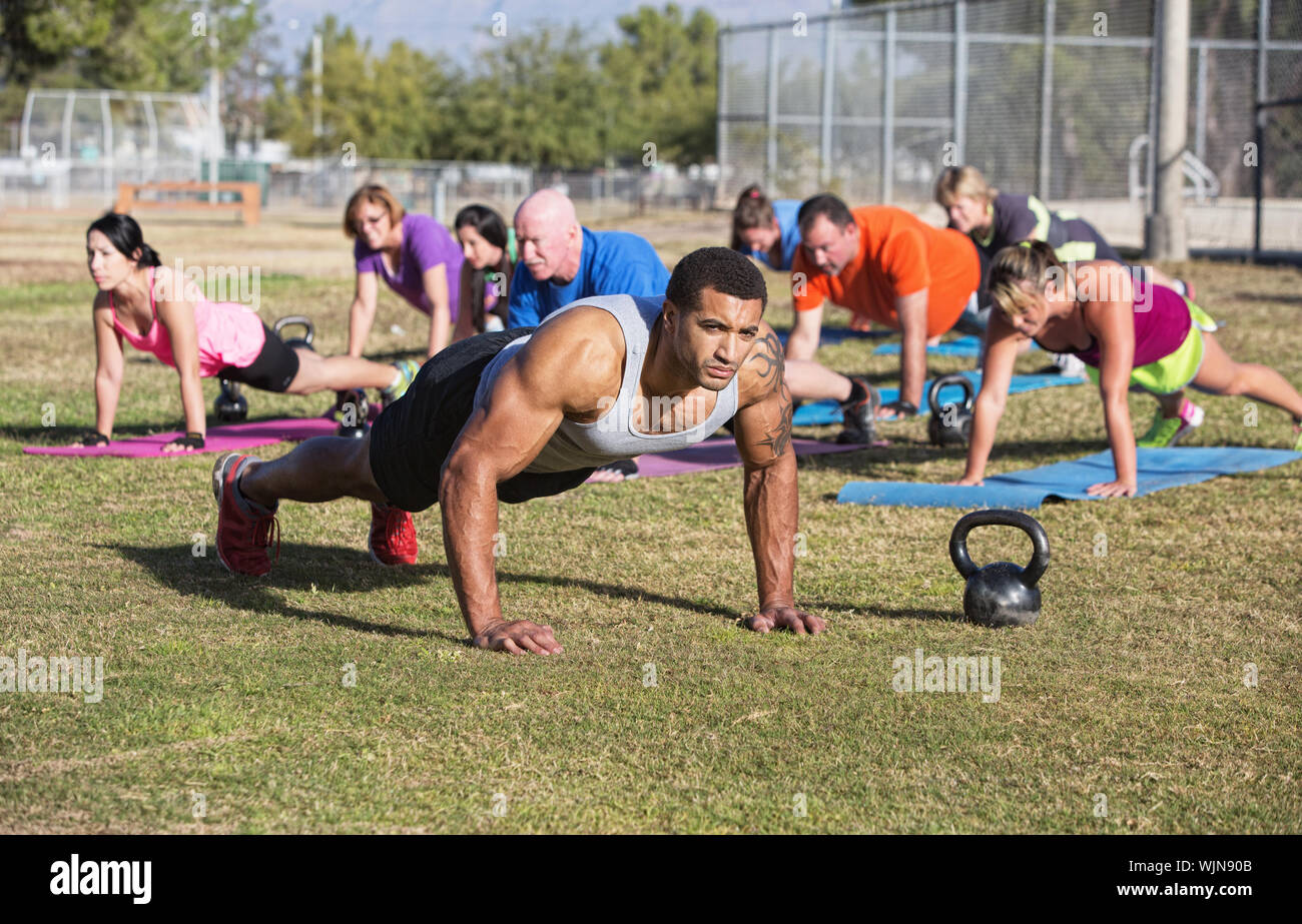 Group of adults exercising in outdoor boot camp Stock Photo - Alamy