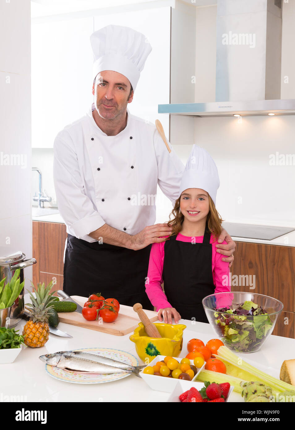 Chef master and junior pupil kid girl at cooking school with food on ...