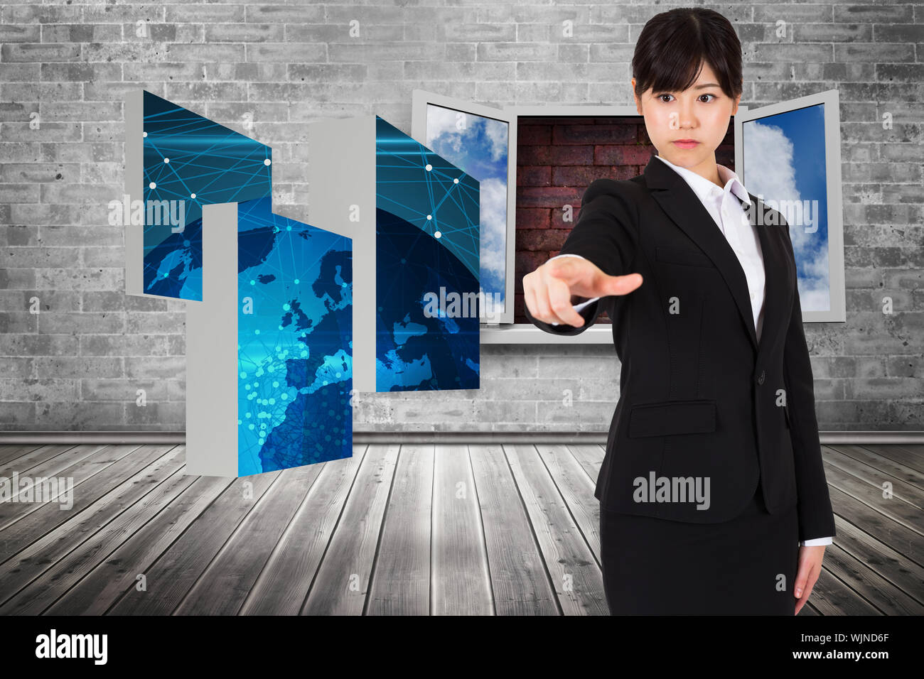 Focused businesswoman pointing against window frame on red brick wall ...