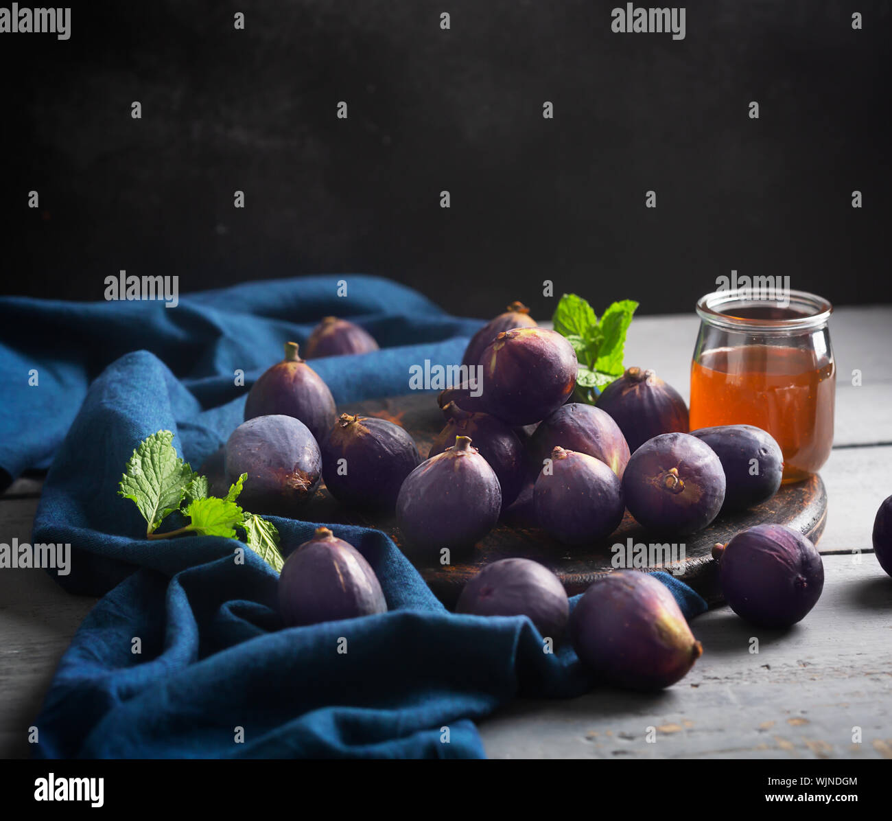 Fresh figs on a dark wood background with honey and mint Stock Photo ...