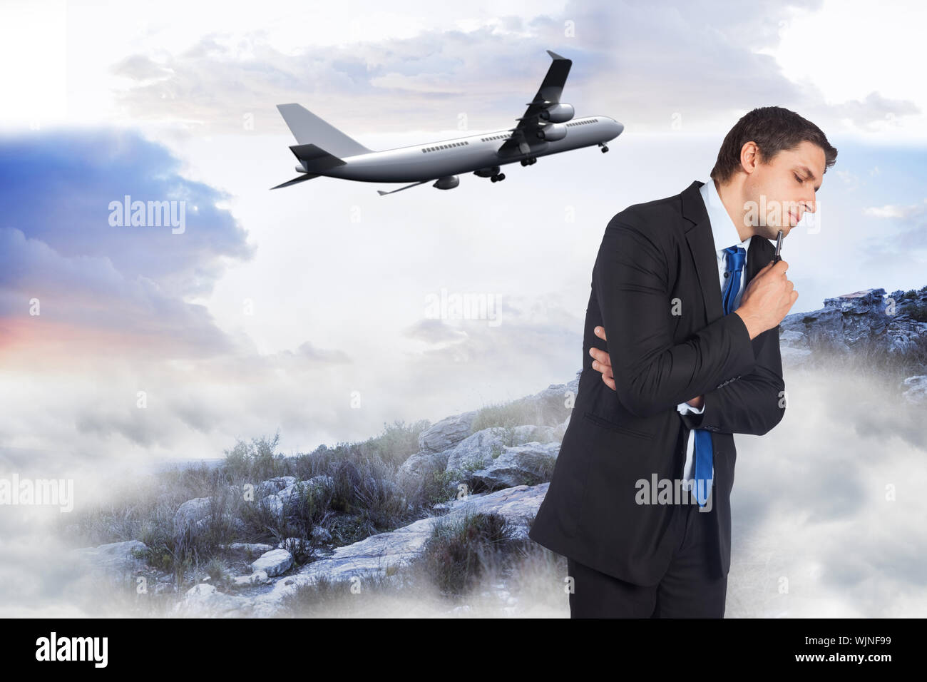 Thinking businessman holding pen against book steps against sky Stock ...