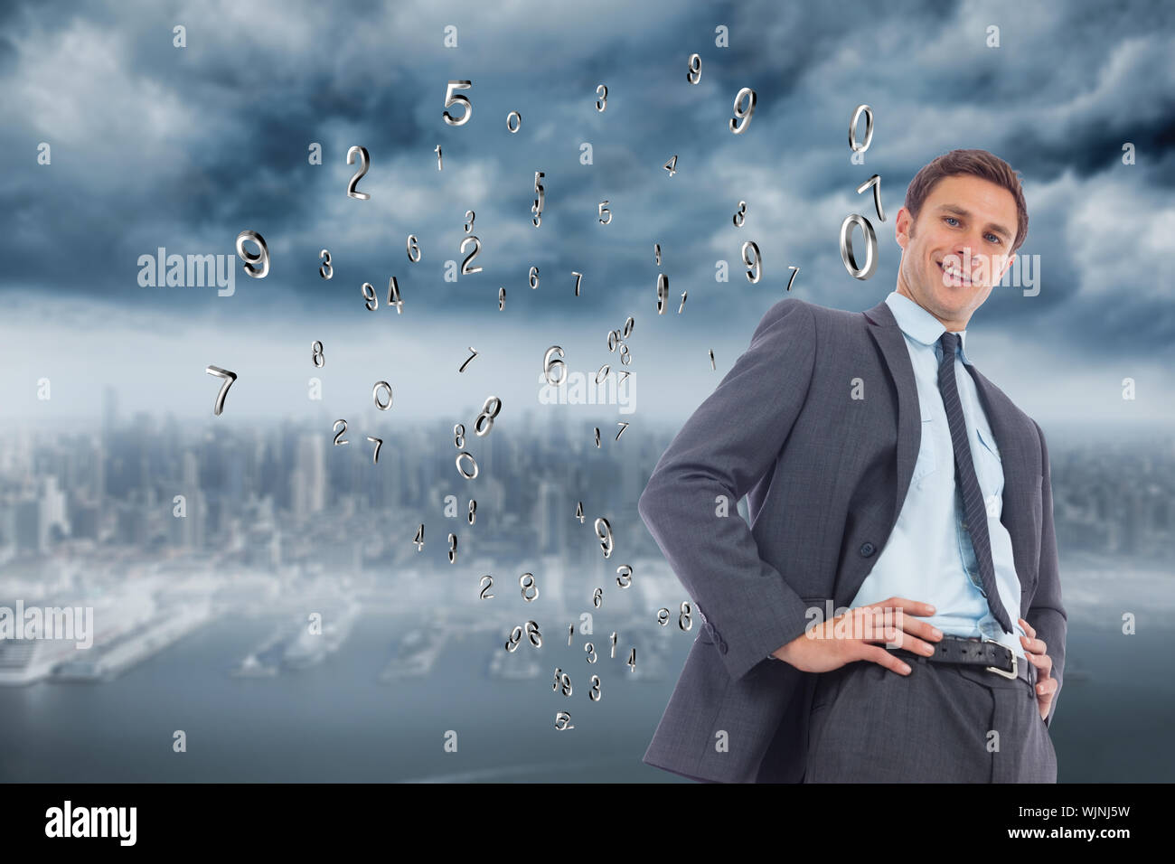 Businessman with hands on hips against room with large windows showing ...