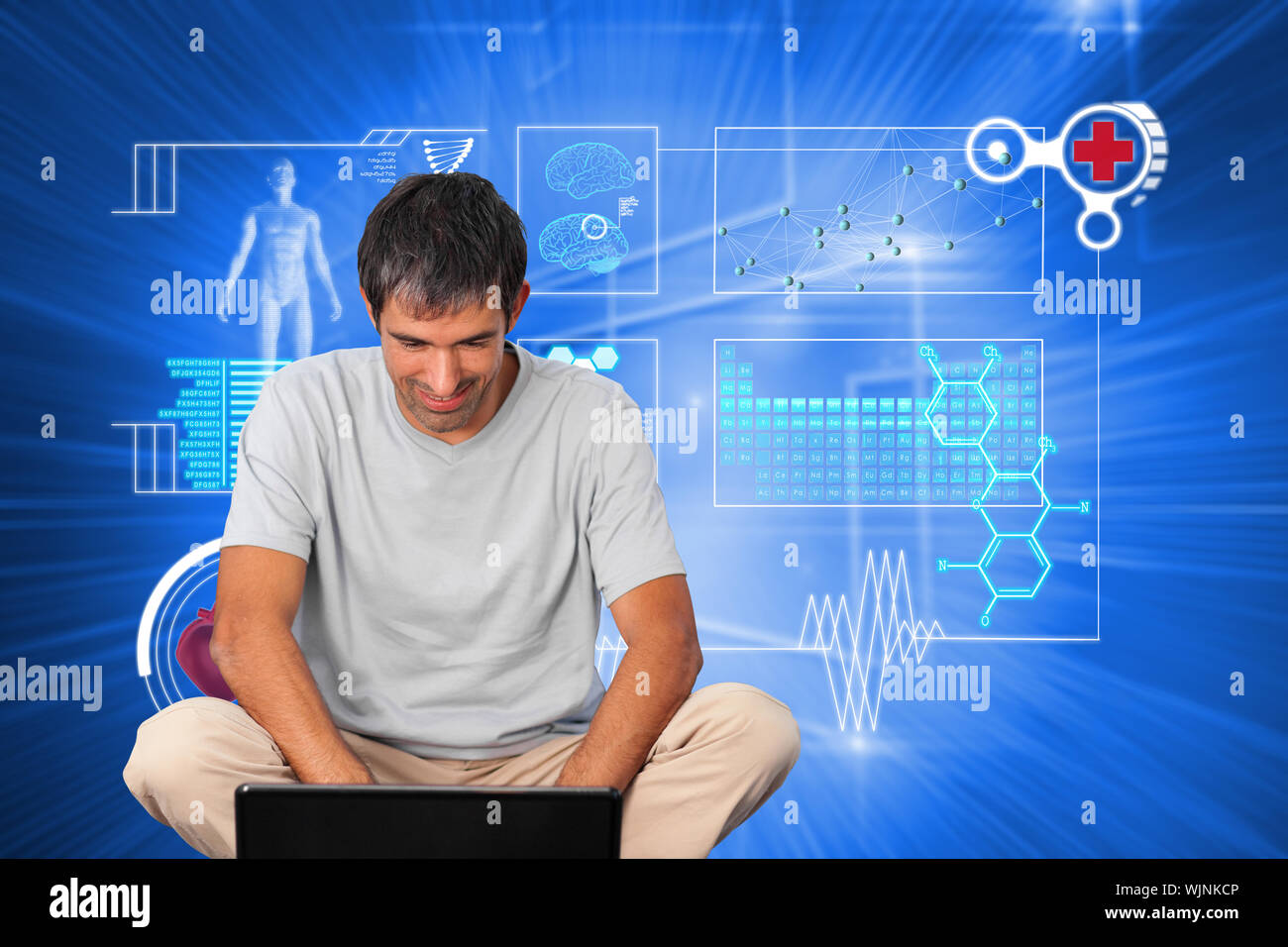 Bright man using a laptop against glowing background with squares Stock ...