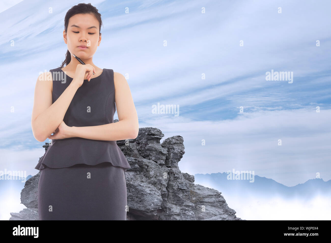 Thinking asian businesswoman against rocky landscape Stock Photo - Alamy