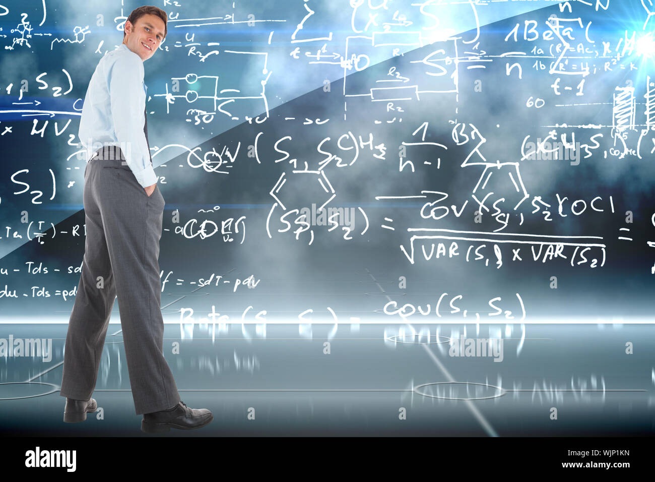 Happy businessman standing with hands in pockets against math equation ...