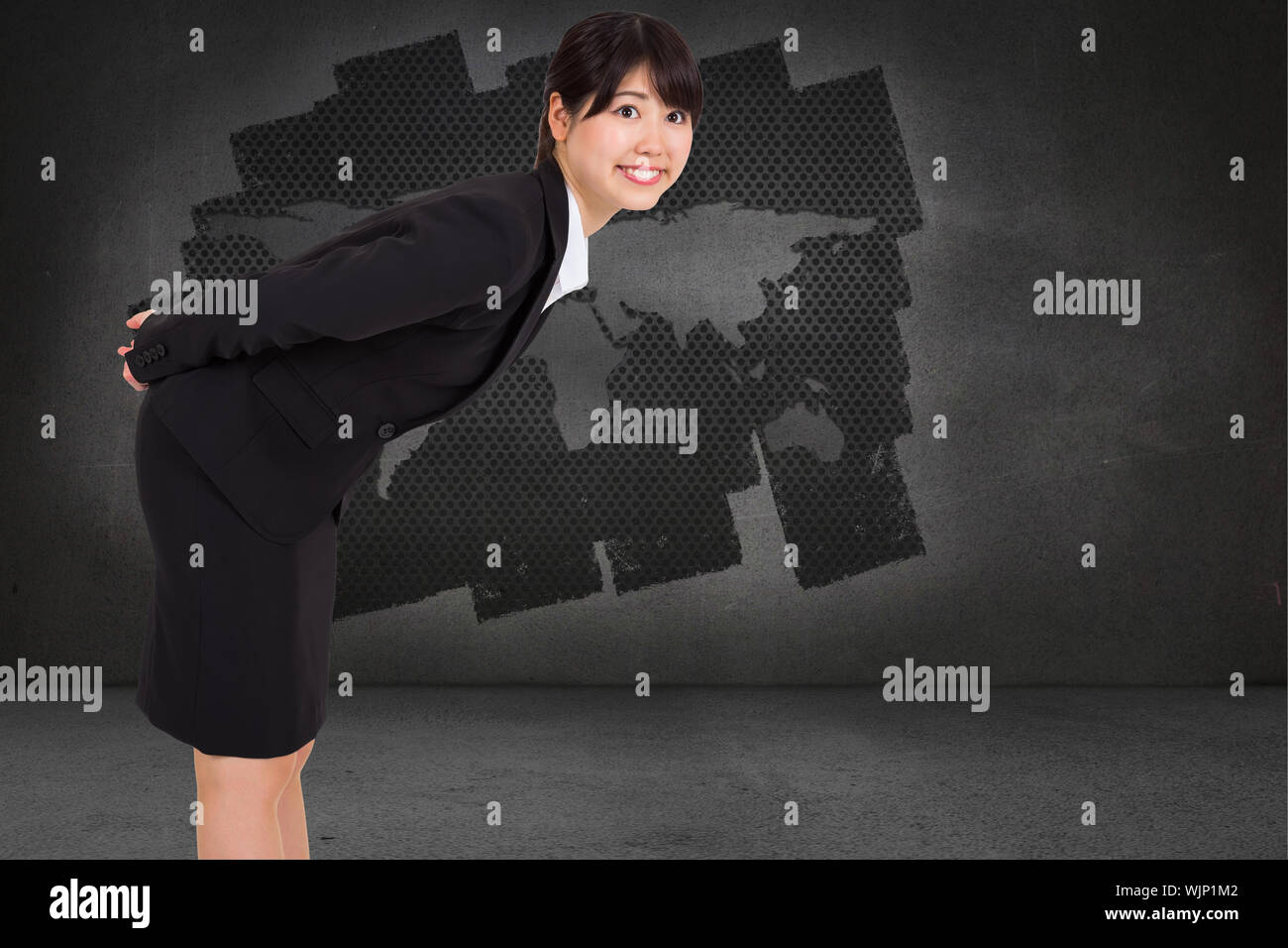 Smiling businesswoman bending against display on wall showing global ...