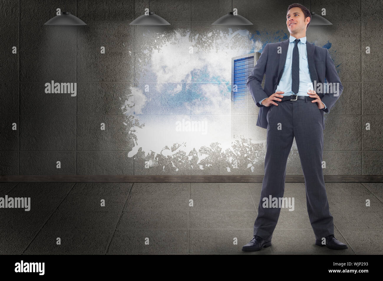 Happy businessman with hands on hips against splash on wall revealing ...