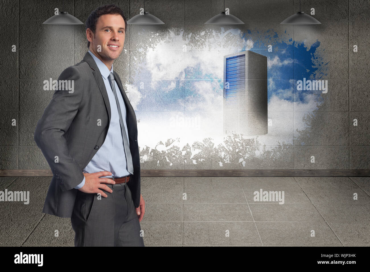 Smiling businessman with hand on hip against splash on wall revealing server tower Stock Photo ...