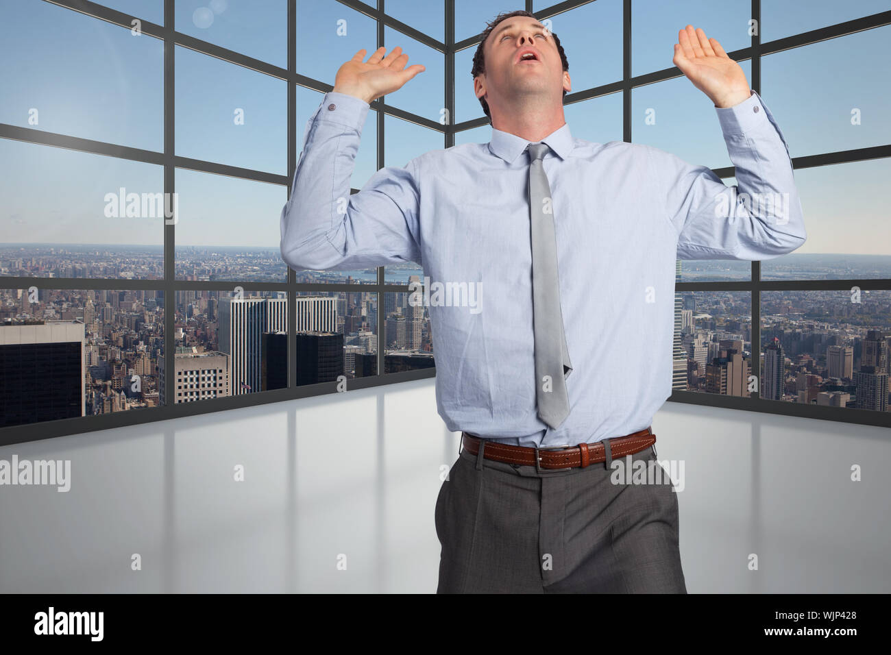 Businessman standing with arms pushing up against room with large ...