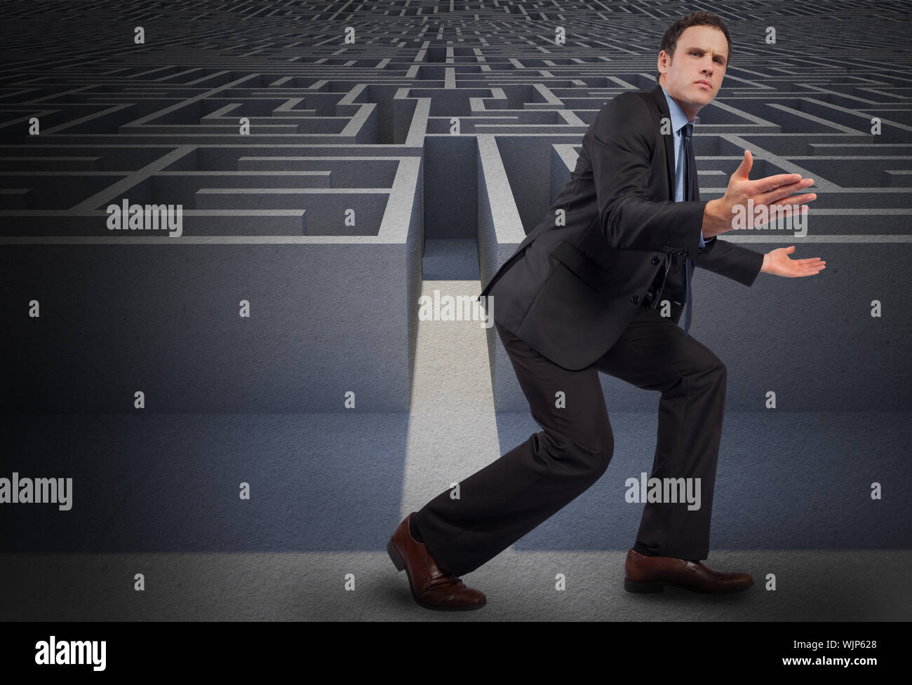 Businessman posing with arms outstretched against entrance to difficult ...