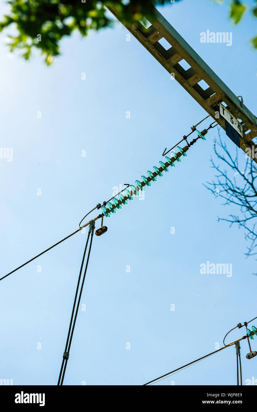 Low angle view of high voltage French power lines against blue sky ...