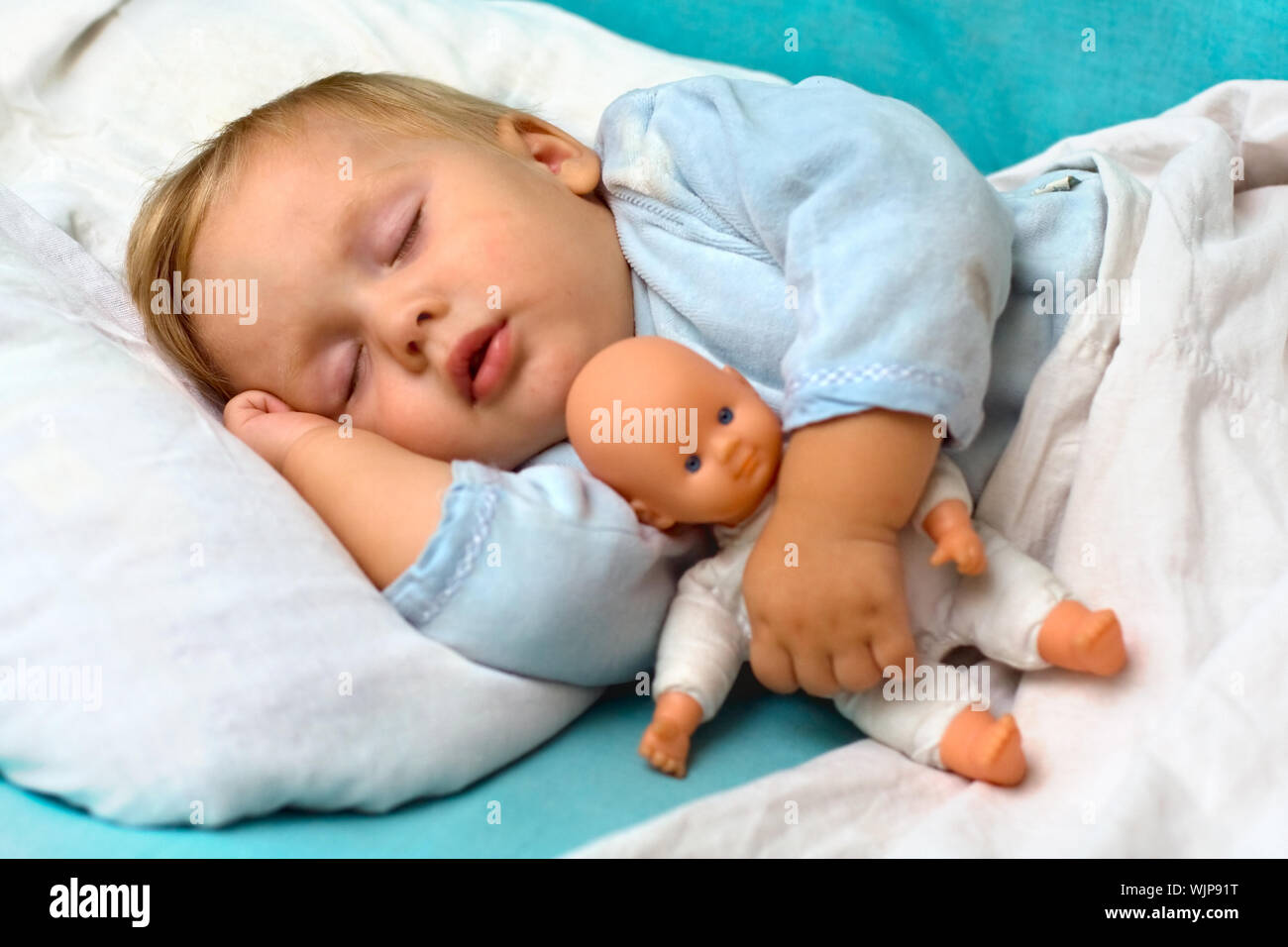 Portrait of toddler child, sleeping in a bed with a toy doll Stock ...