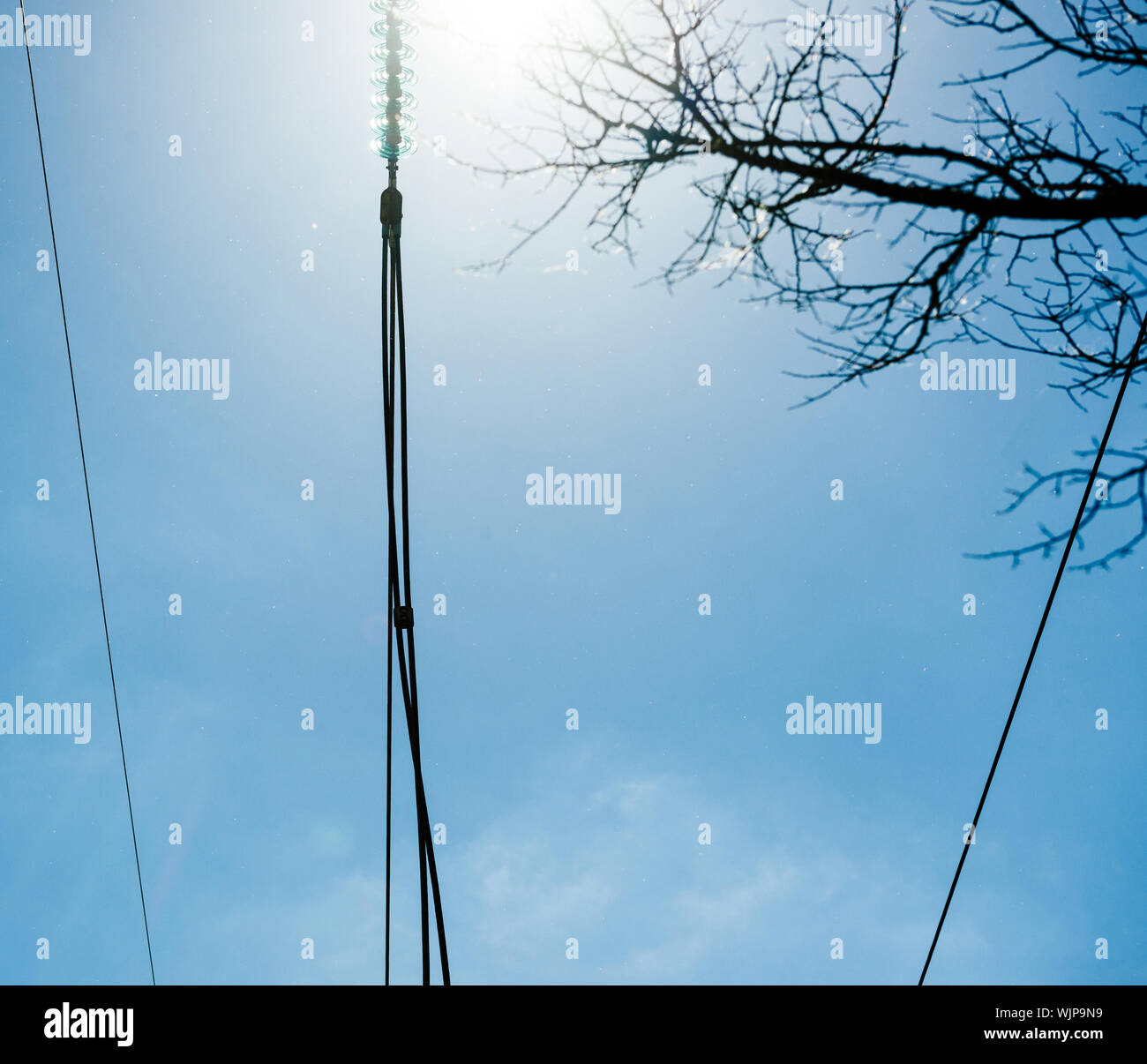 Low angle detail view of high voltage French power lines against blue ...