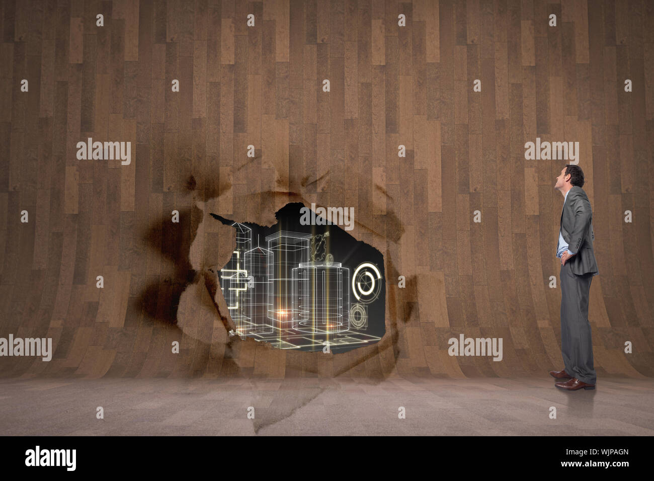 Smiling businessman with hands on hips against rip on wall showing ...