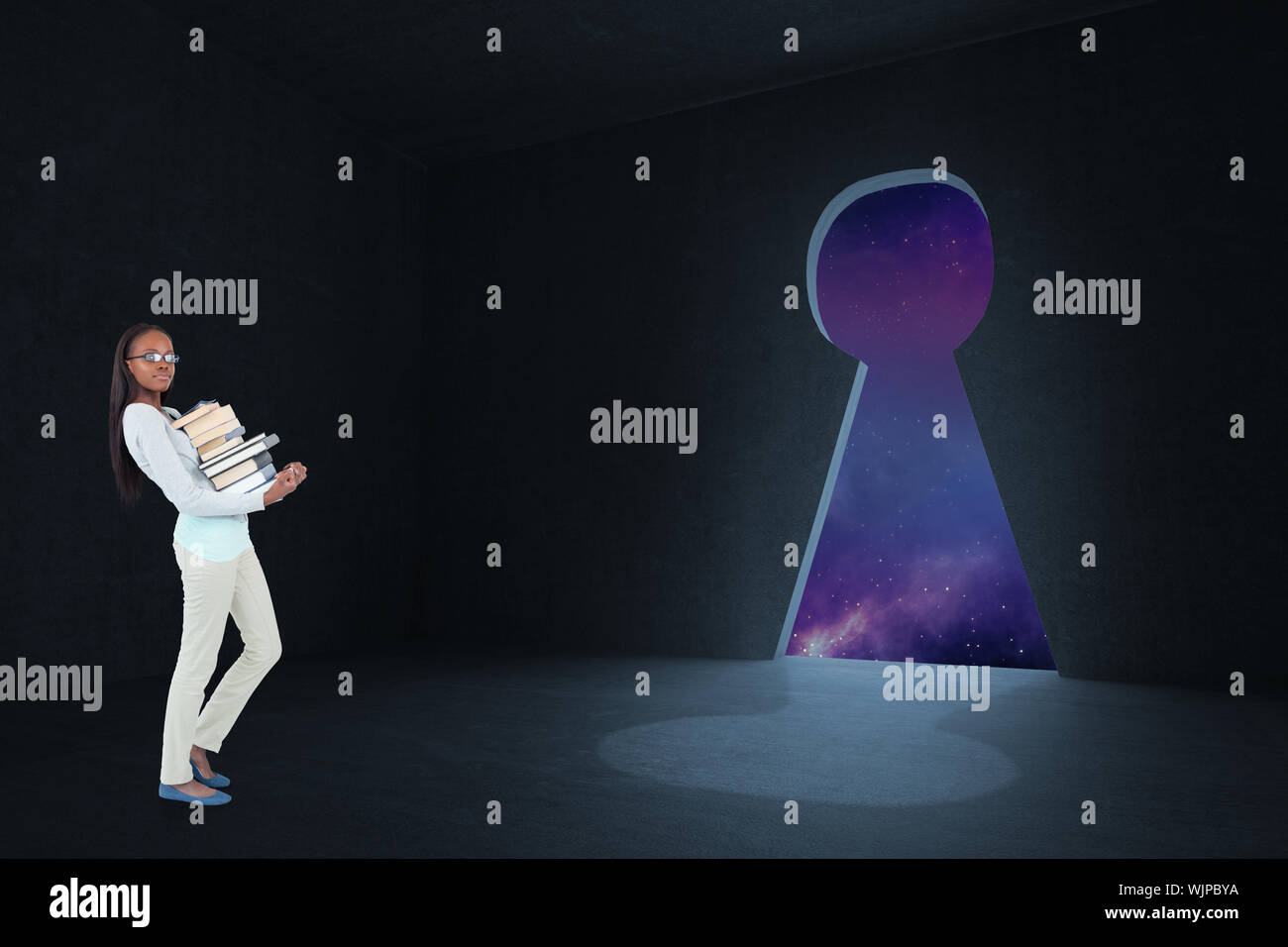 Side view of young woman carrying a pile of books against keyhole door ...