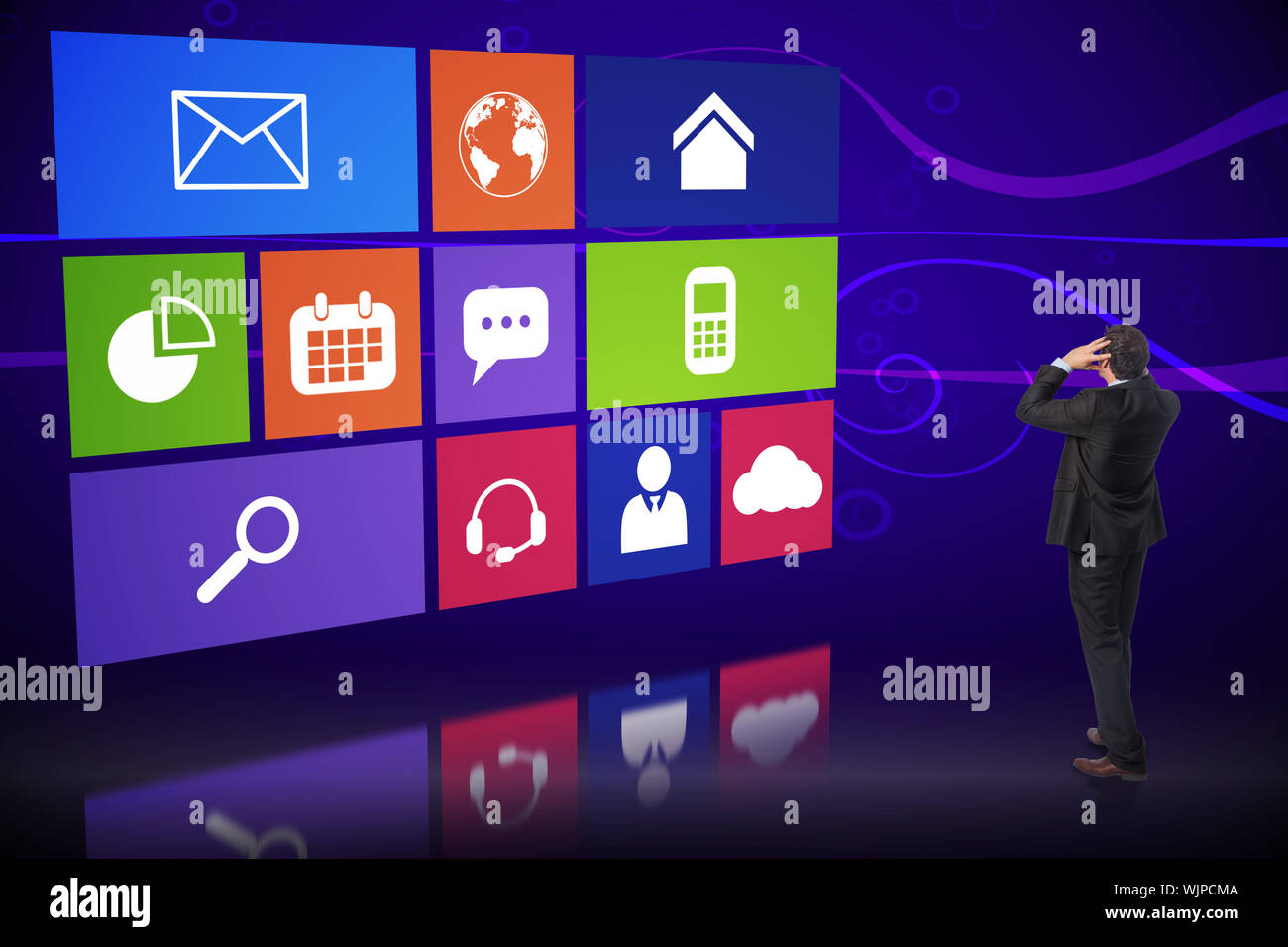 Stressed businessman with hands on head against computer applications ...