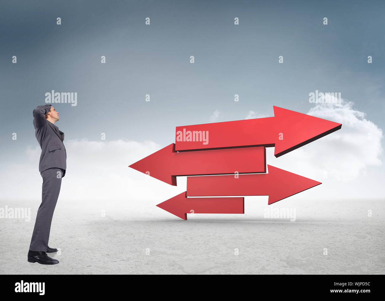 Thinking businessman scratching head against red arrows in a desert ...