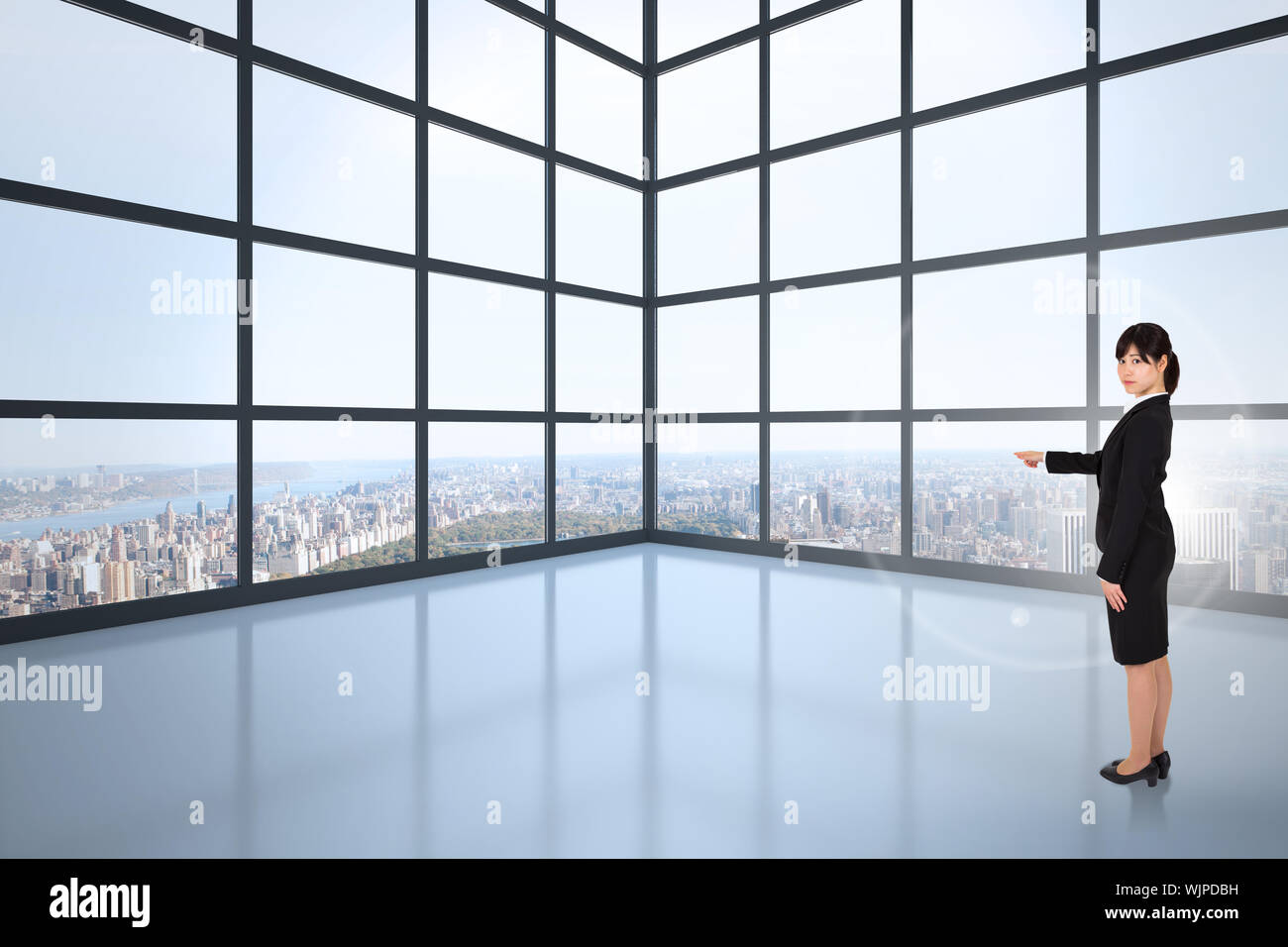 Focused businesswoman against room with large window showing city Stock ...
