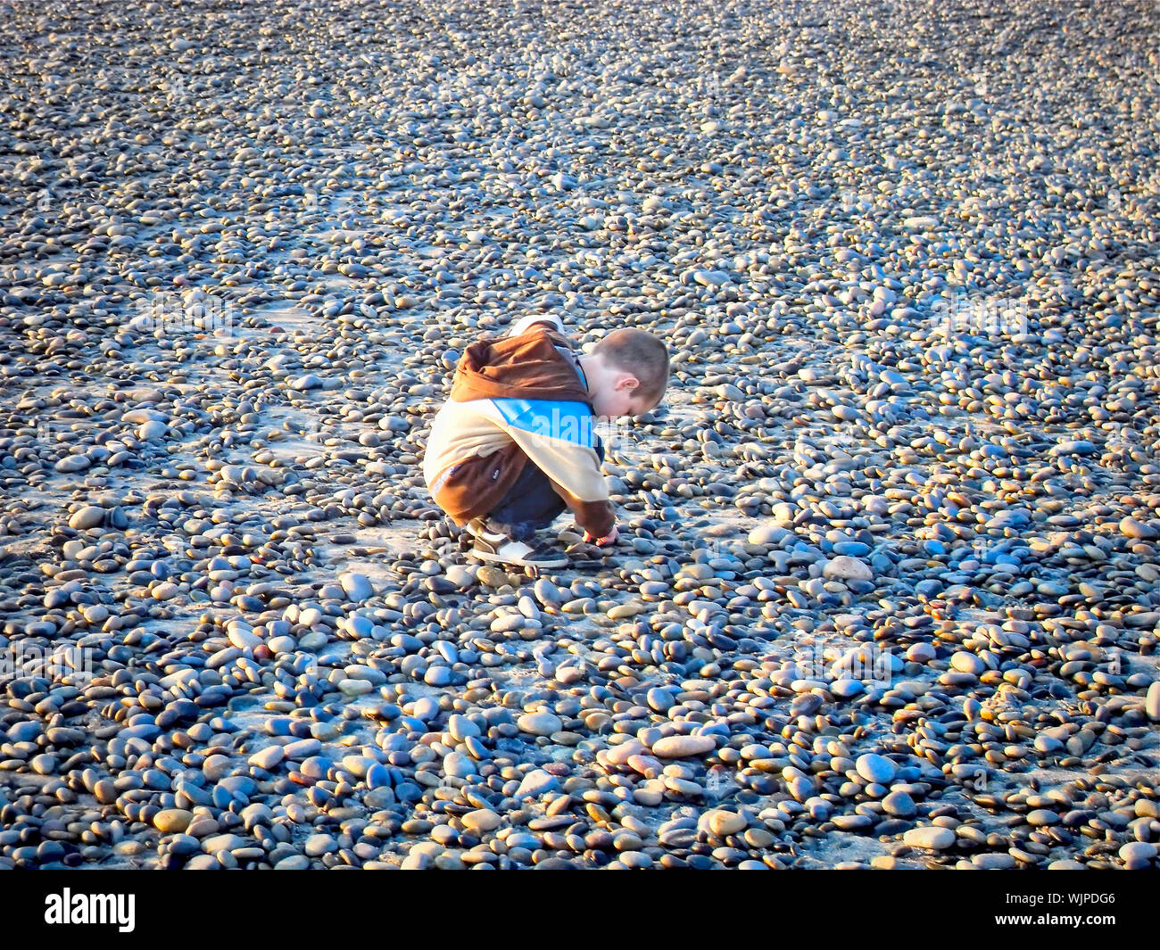 Boy sitting on stone hi-res stock photography and images - Alamy