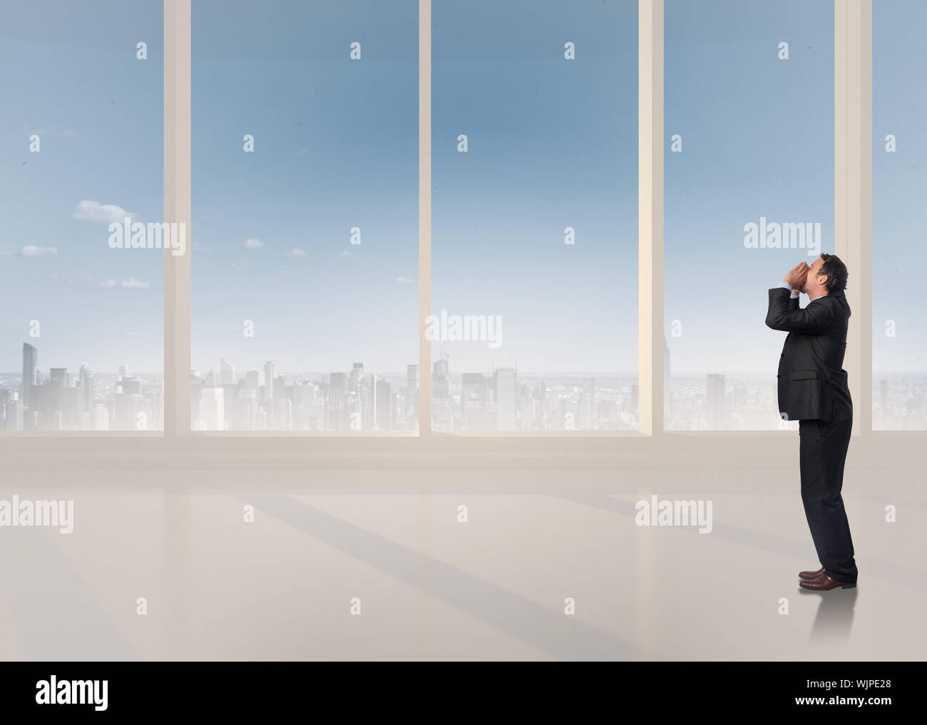 Shouting businessman against bright white room with windows Stock Photo ...