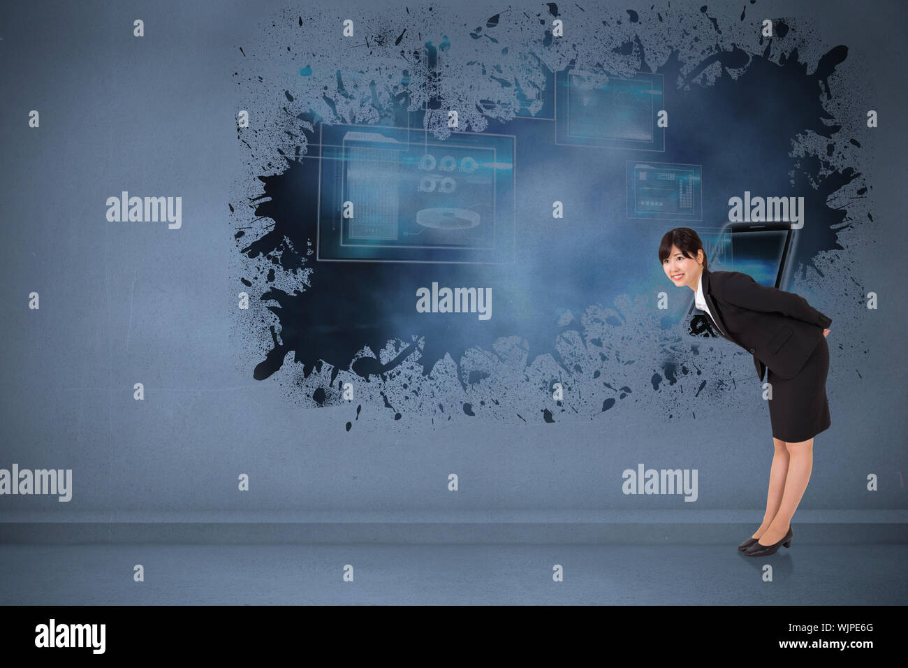 Smiling businesswoman bending against splash on wall revealing ...