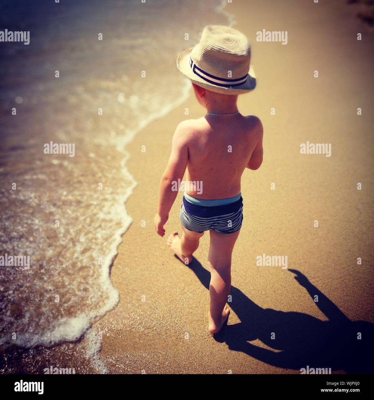Boy walking rear view shadow hi-res stock photography and images - Alamy