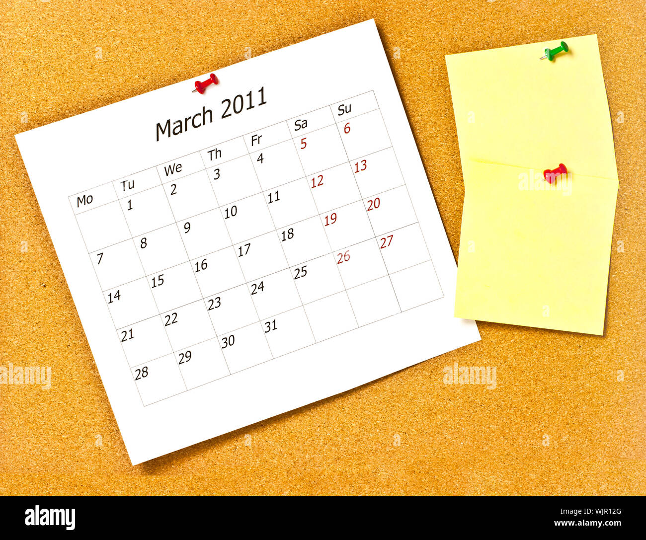 Cork bulletin board to pin a calendar page and yellow sticky paper ...