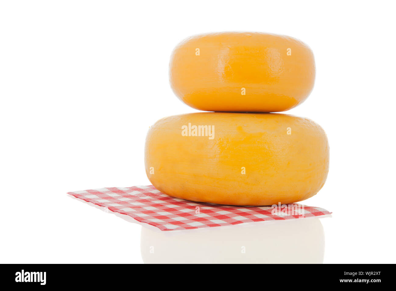 Two whole cheeses on checked napkin isolated over white background ...