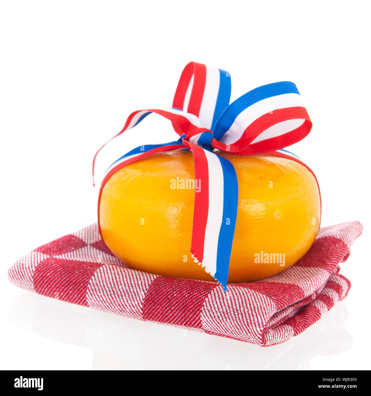 Two whole dutch cheeses with ribbon in flag colors on checked napkin ...