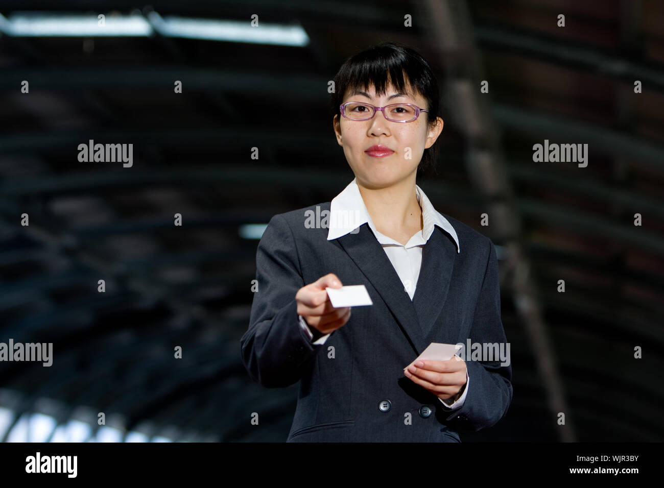 Asian woman giving her business calling card with a friendly smile ...