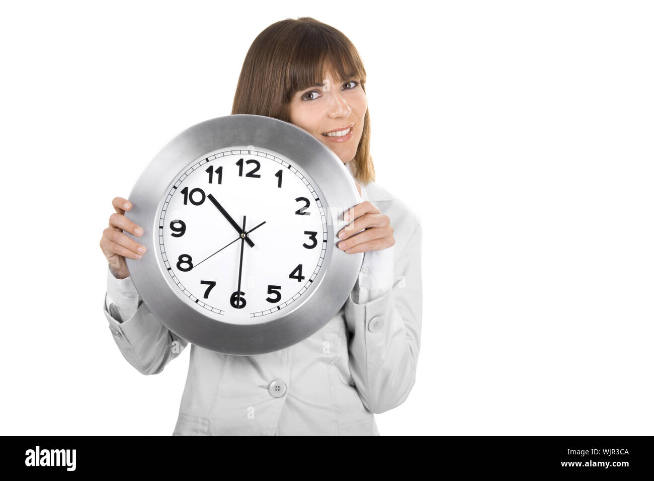 Beautiful woman standing over a white background holding a clock Stock ...