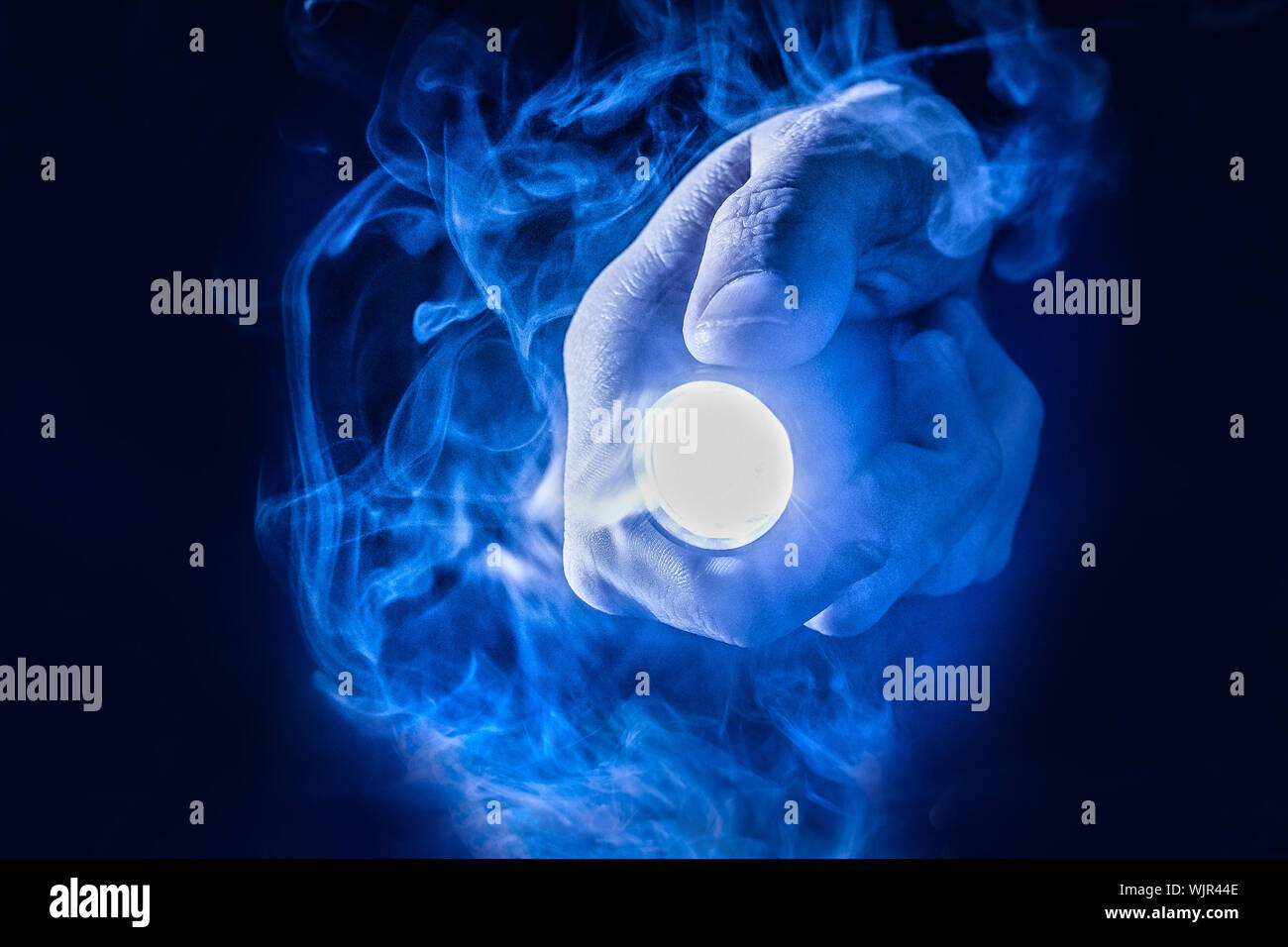 Hand holding a flashlight in the middle of mist Stock Photo - Alamy