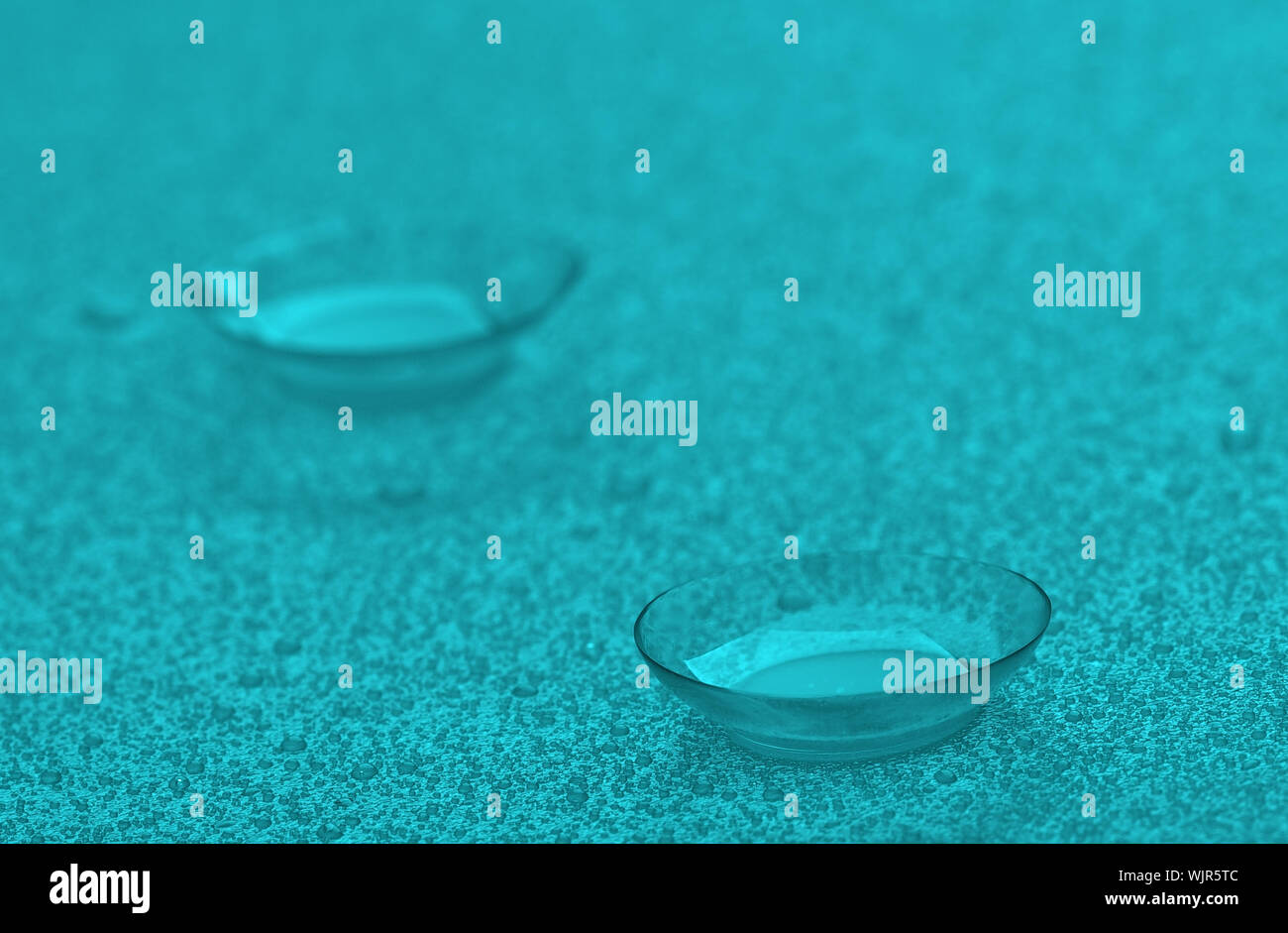 Two Contact Lenses with Water Droplets isolated on Wet background ...